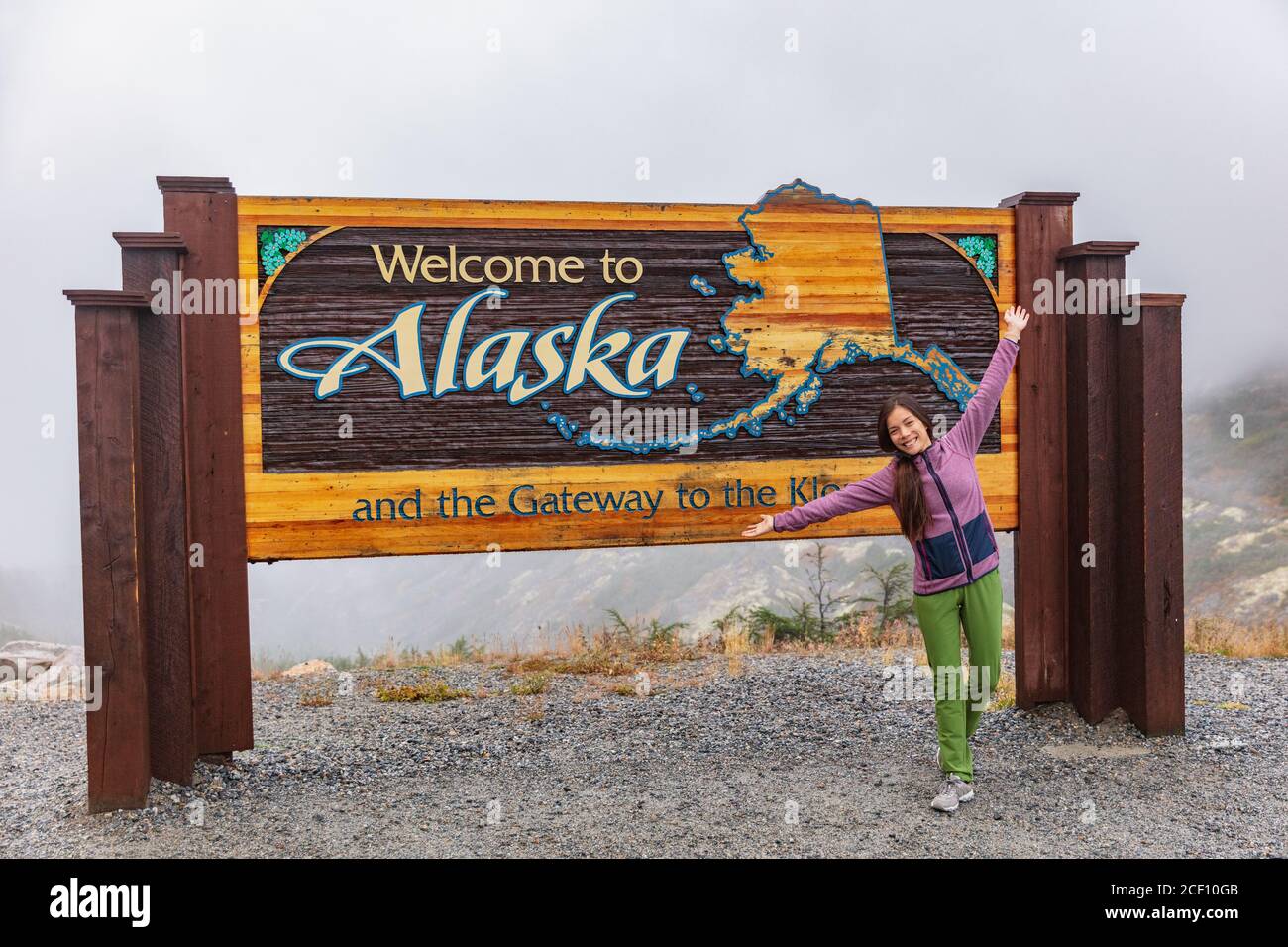 Alaska border sign tourist posing at welcome billboard - Happy Asian ...