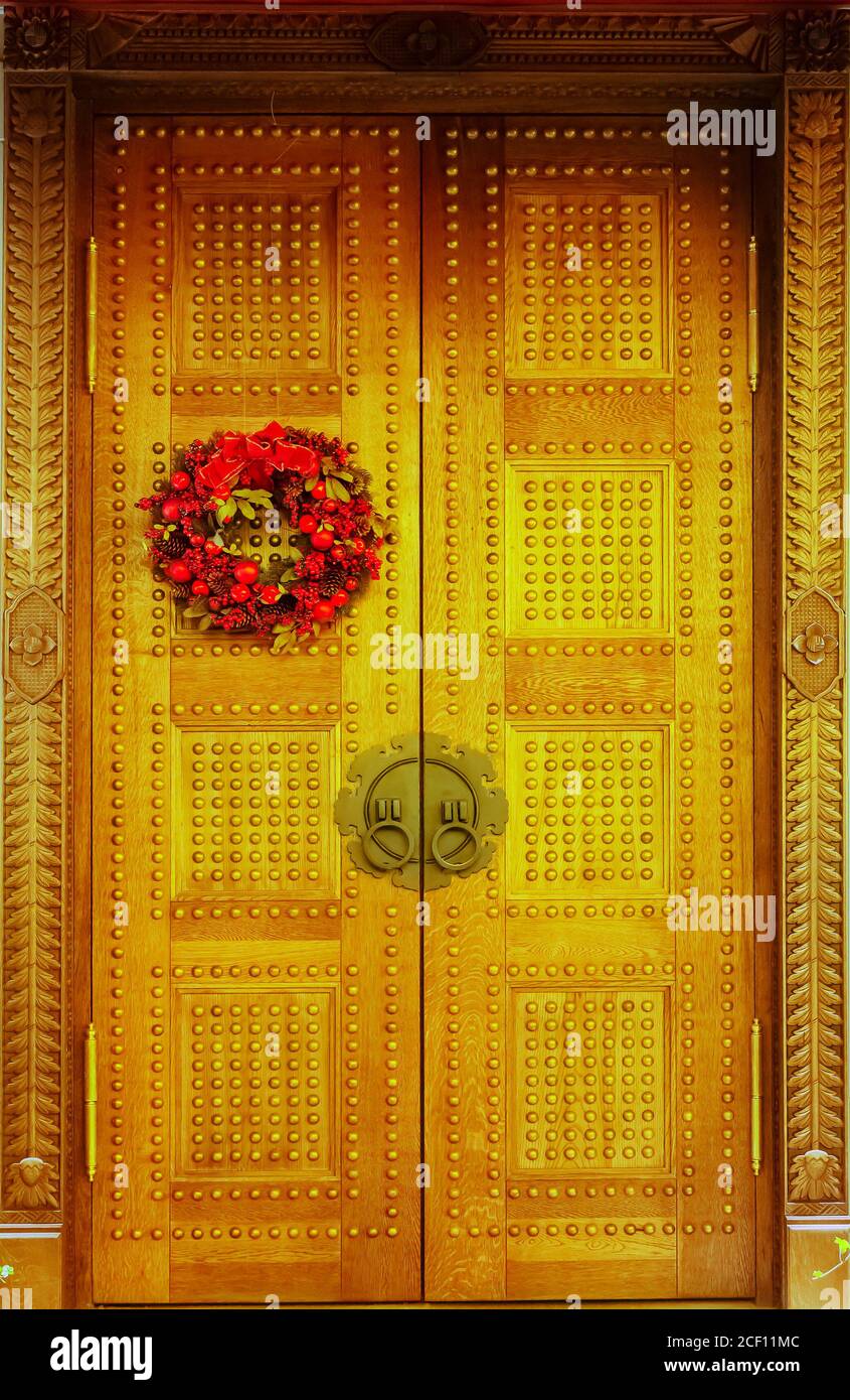 Wooden patterned doors of golden color with carved platbands and with a ...