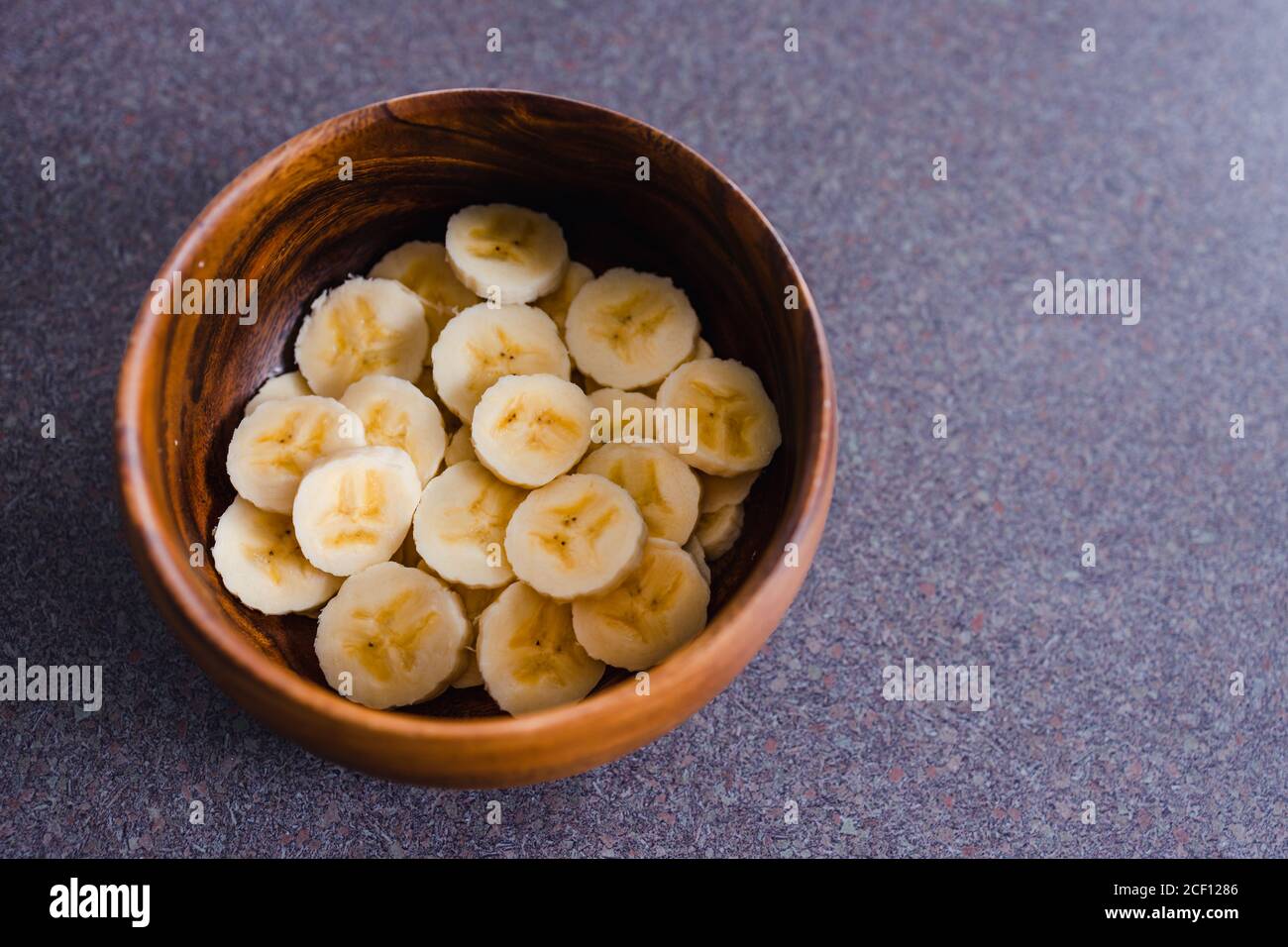 simple food ingredients concept, sliced banana in wooden bowl as ...