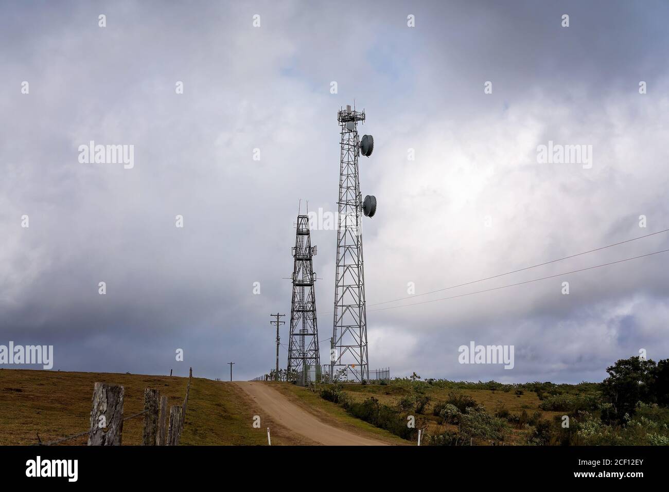 Modern technology communication towers beside a dirt road in a rural ...