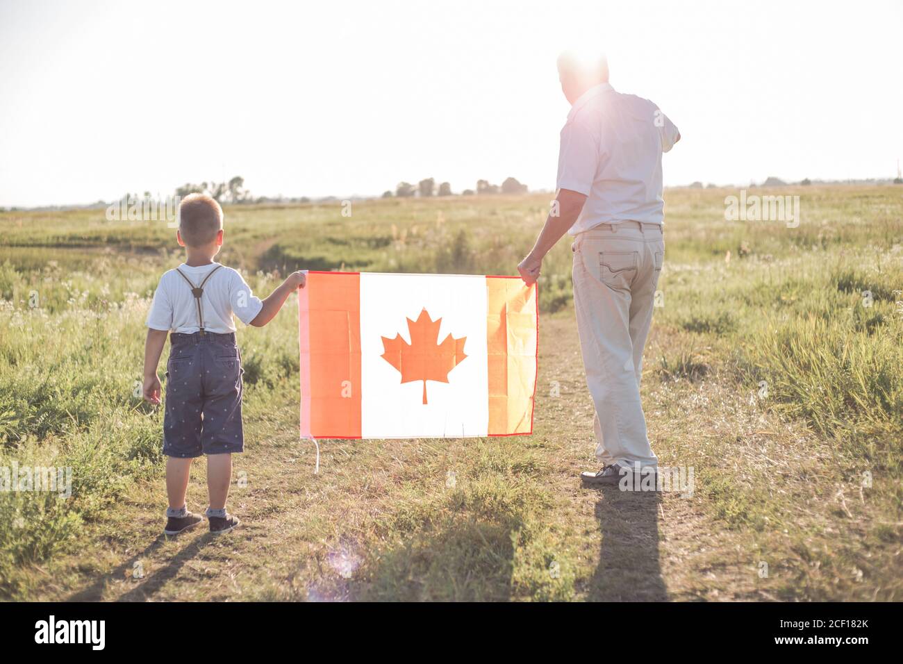 Attractive old senior man and grahdson holding Canadian Flag. National ...