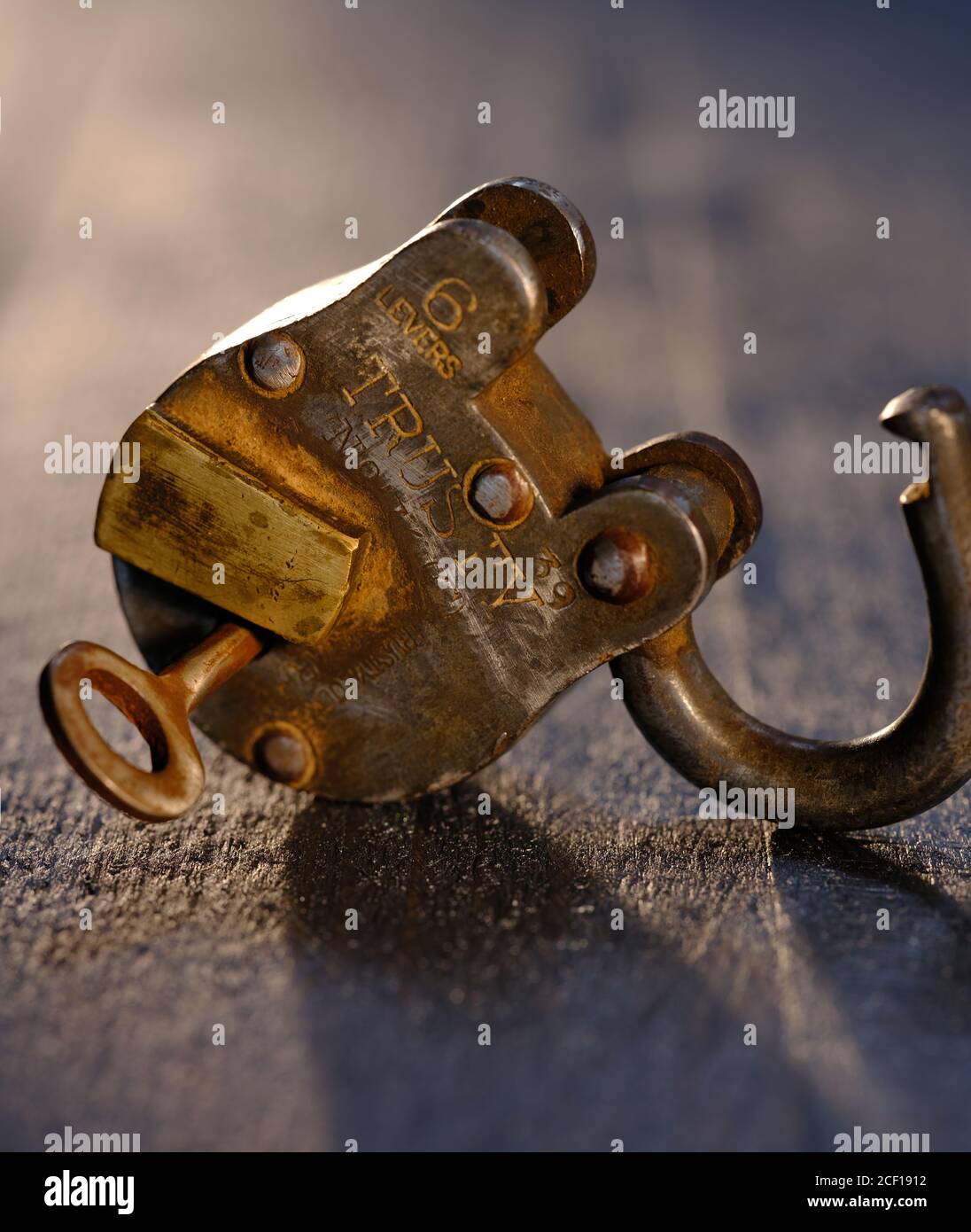 Trusty Padlock with key on weatehered textured wooden table top book ...