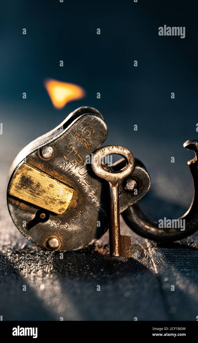Trusty Padlock with key on weatehered textured wooden table top book ...