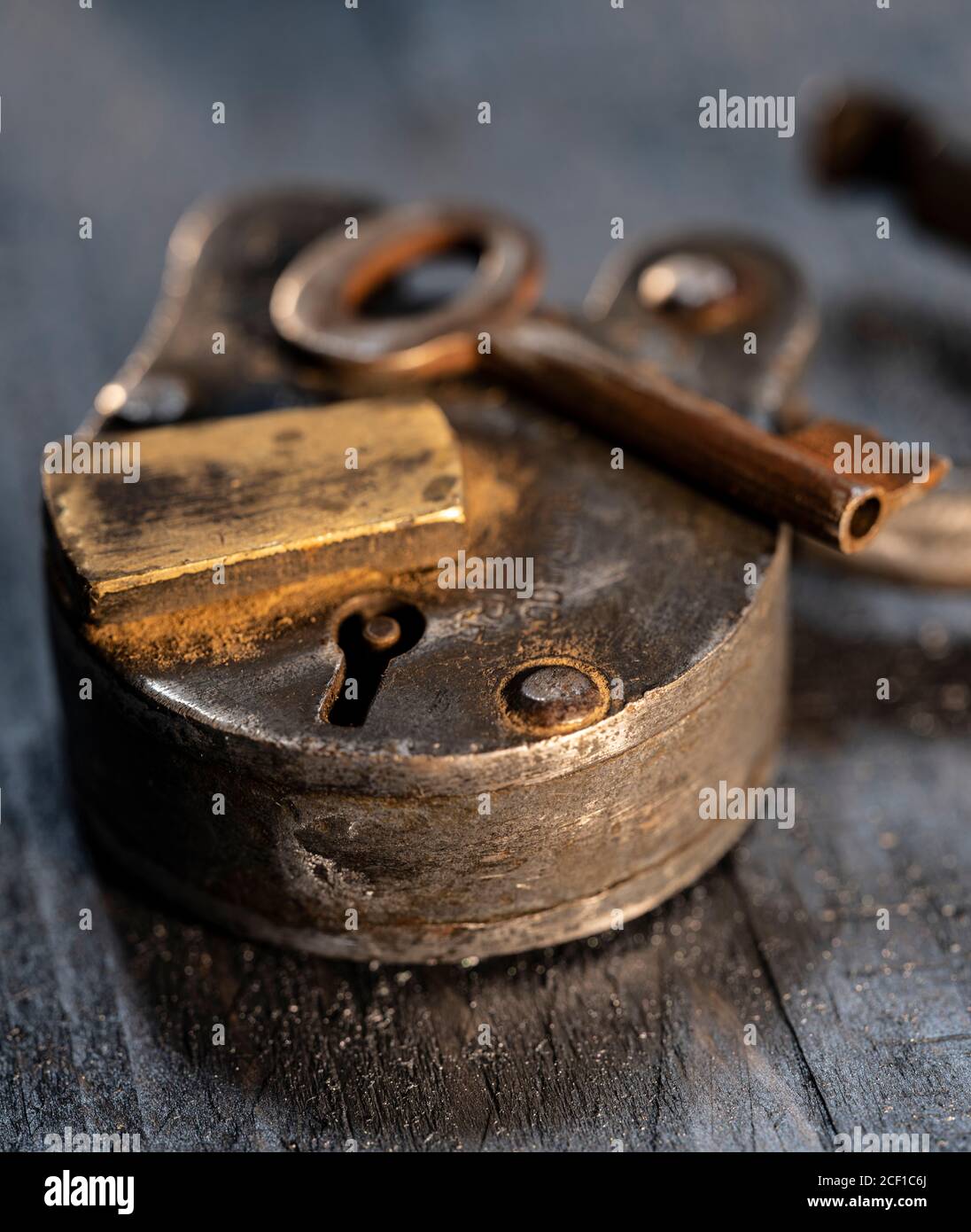 Trusty Padlock with key on weatehered textured wooden table top book ...