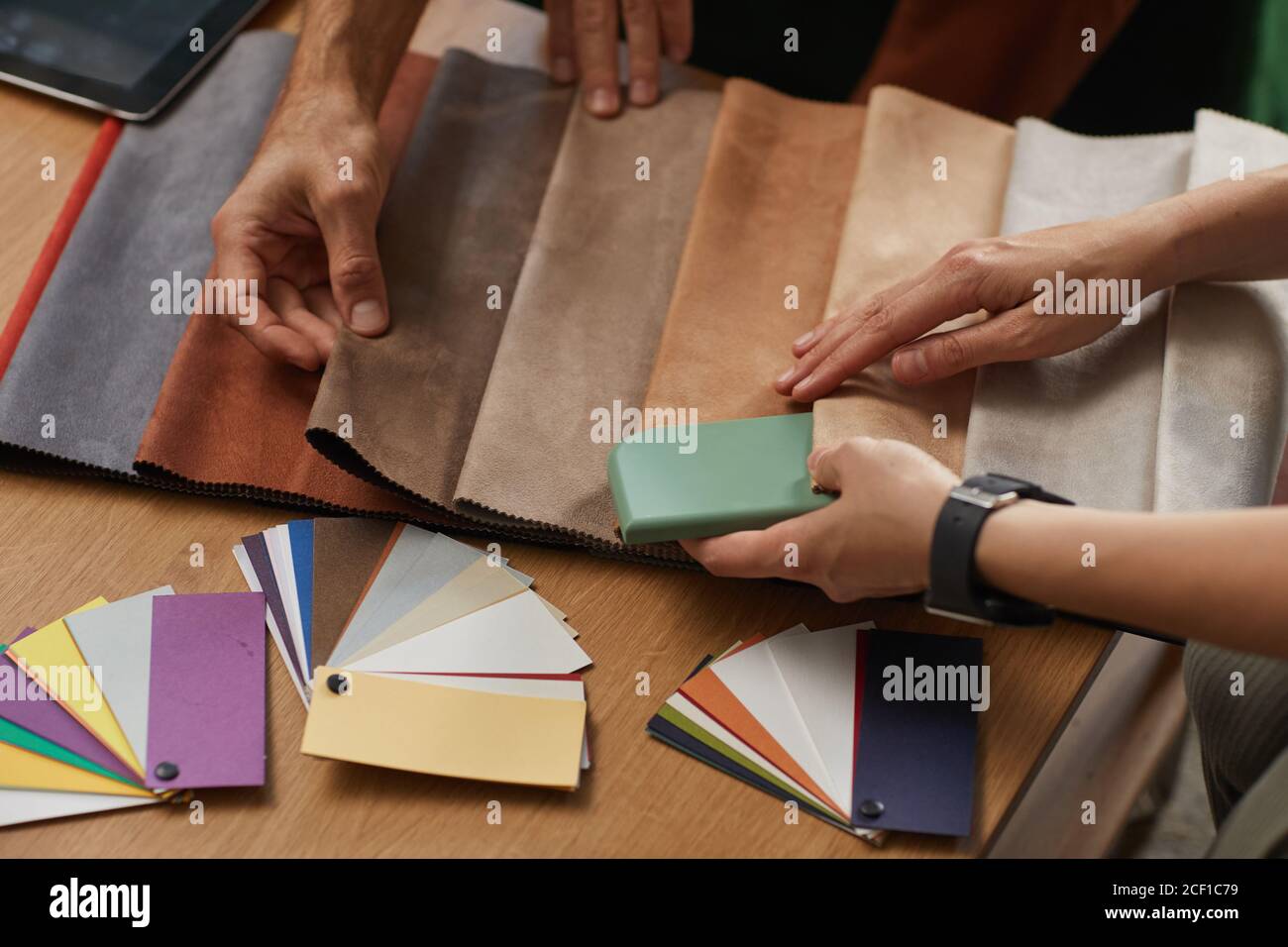 Close-up of designers of interior working at the table with samples ...