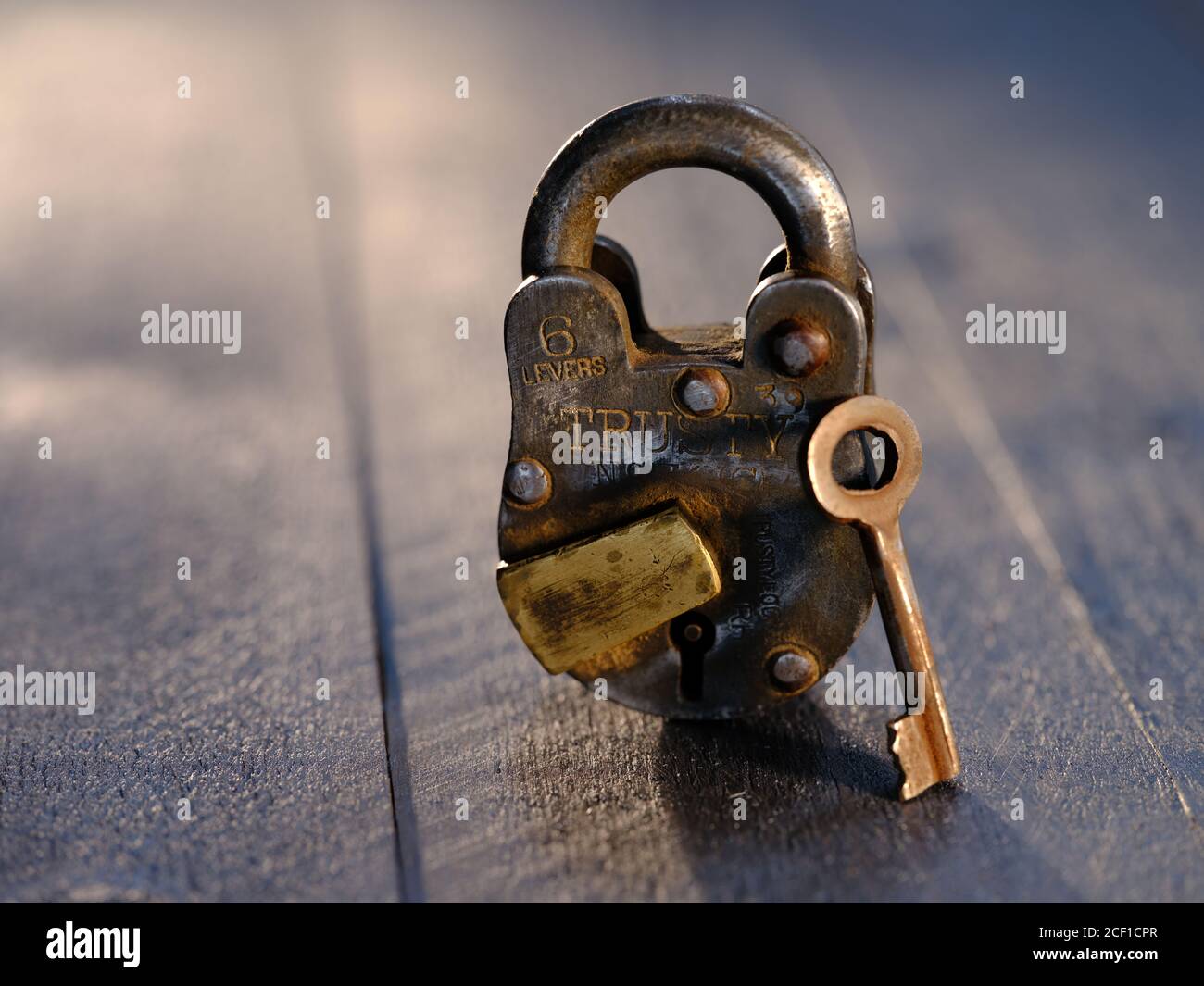 Trusty Padlock with key on weatehered textured wooden table top Stock ...