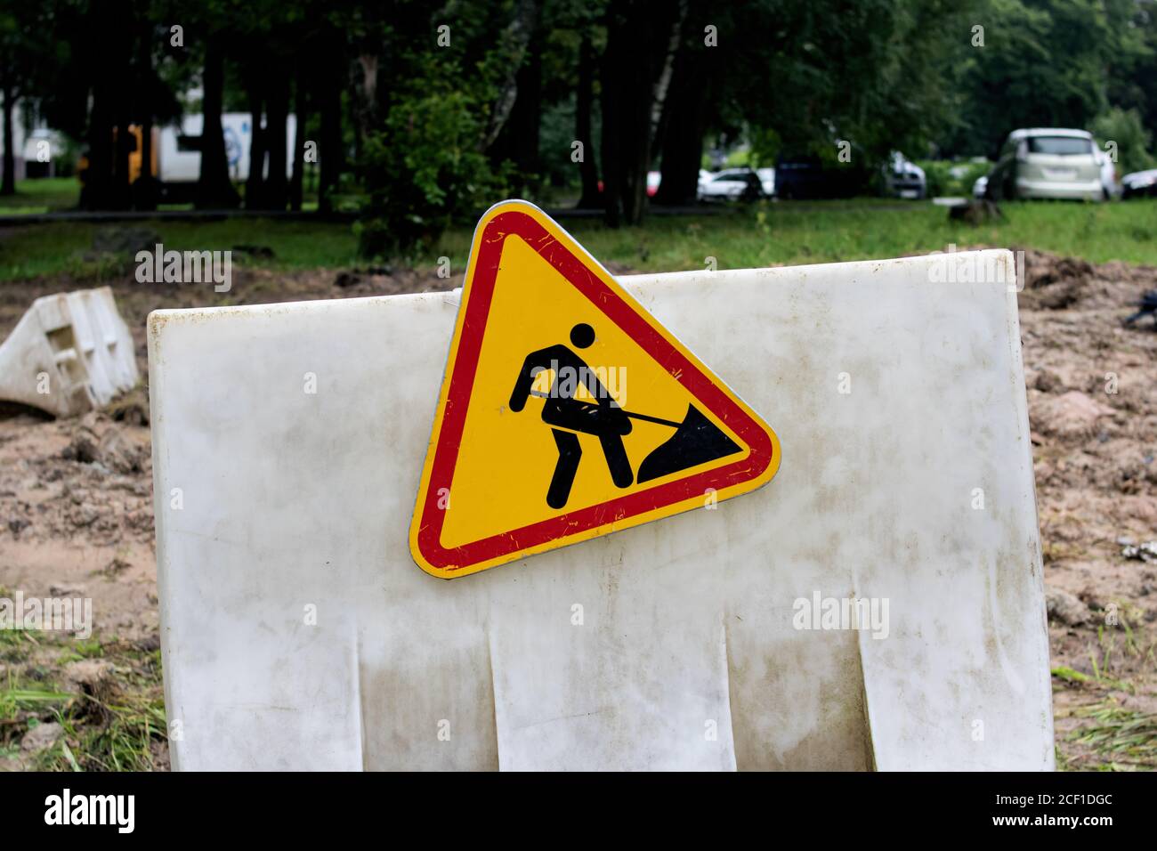 Construction work sign on fence on grass Stock Photo - Alamy