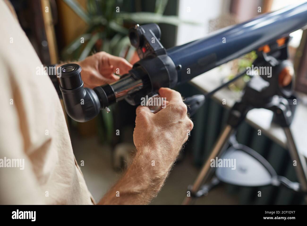 Close-up of male hands holding the telescope he watching on the sky ...
