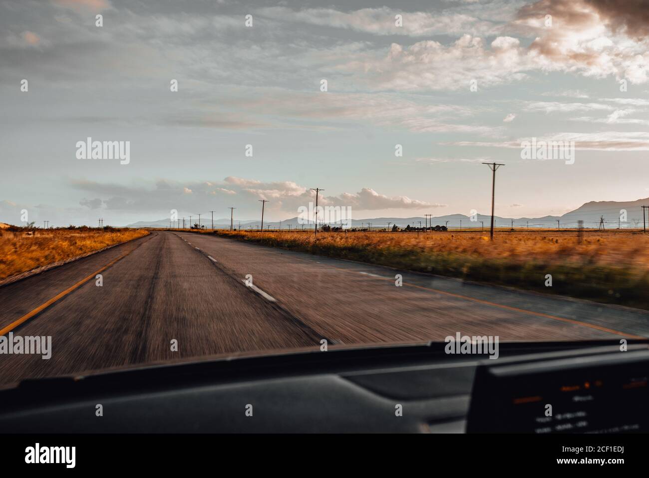 Car driving in the road surrounded by fields Stock Photo - Alamy