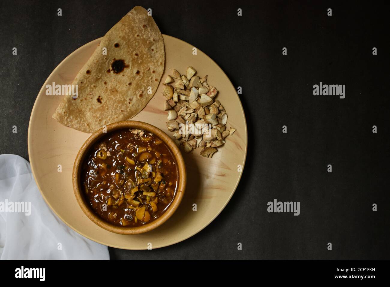 seasonal mushroom vegetable with bread/chapati on a black background ...