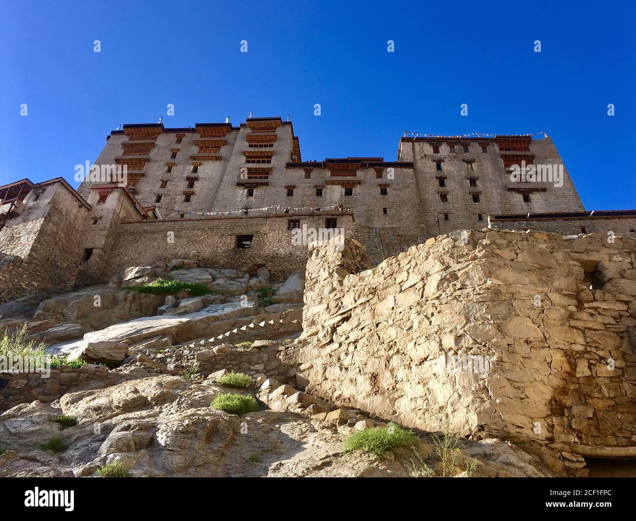 Low angle shot of the facade of a monastery on a mountain in Ladakh ...