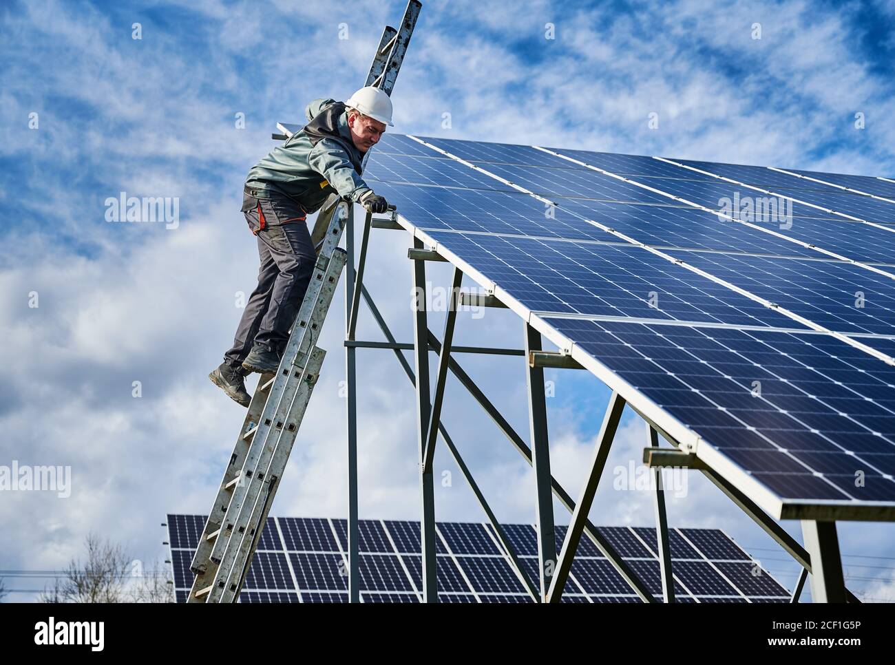 Full length of man electrician standing on ladder and repairing ...
