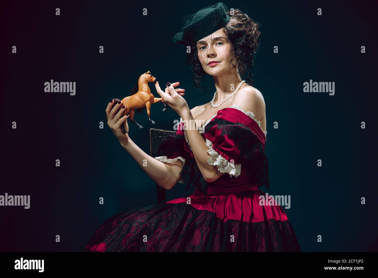 Playing. Young woman as Anna Karenina isolated on dark blue background ...