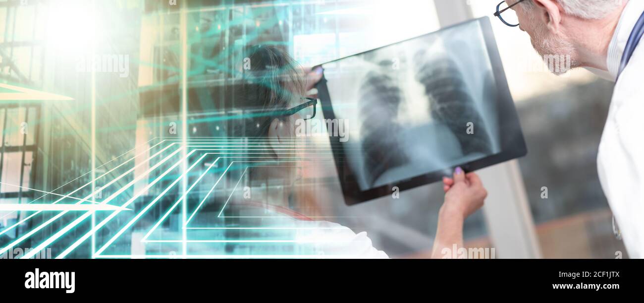 Two doctors examining x-ray report in medical office; multiple exposure ...
