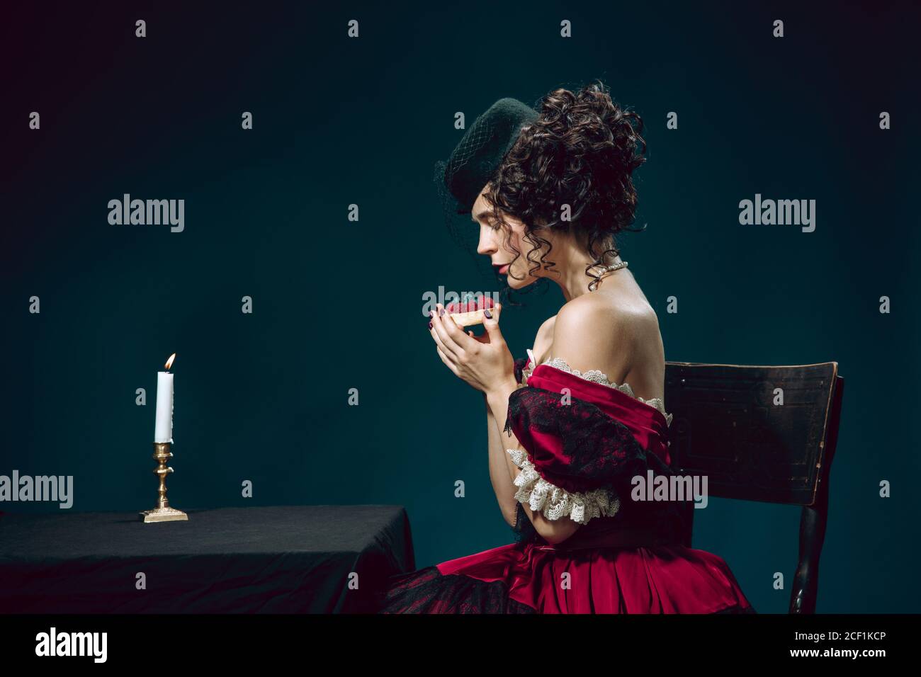 Diet and sweets. Young woman as Anna Karenina isolated on dark blue ...