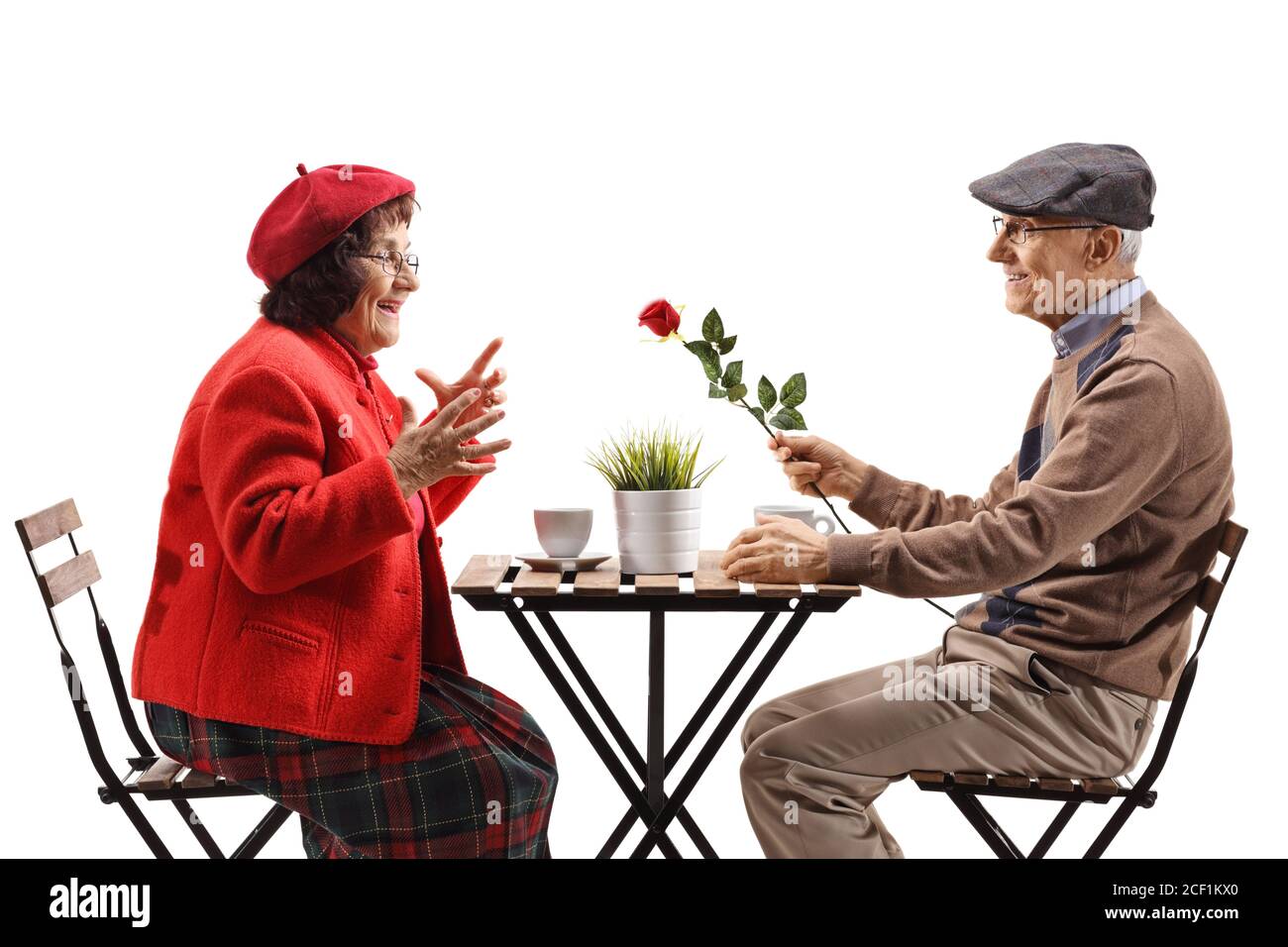 Elderly man giving a red rose to an elderly lady at a restaurant ...