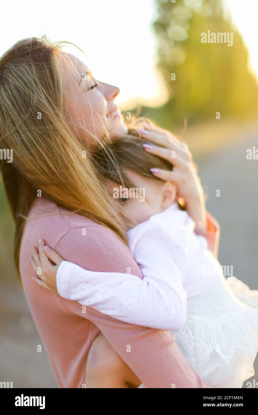 Portrait of young american mother hugging little daughter and smiling Stock Photo - Alamy