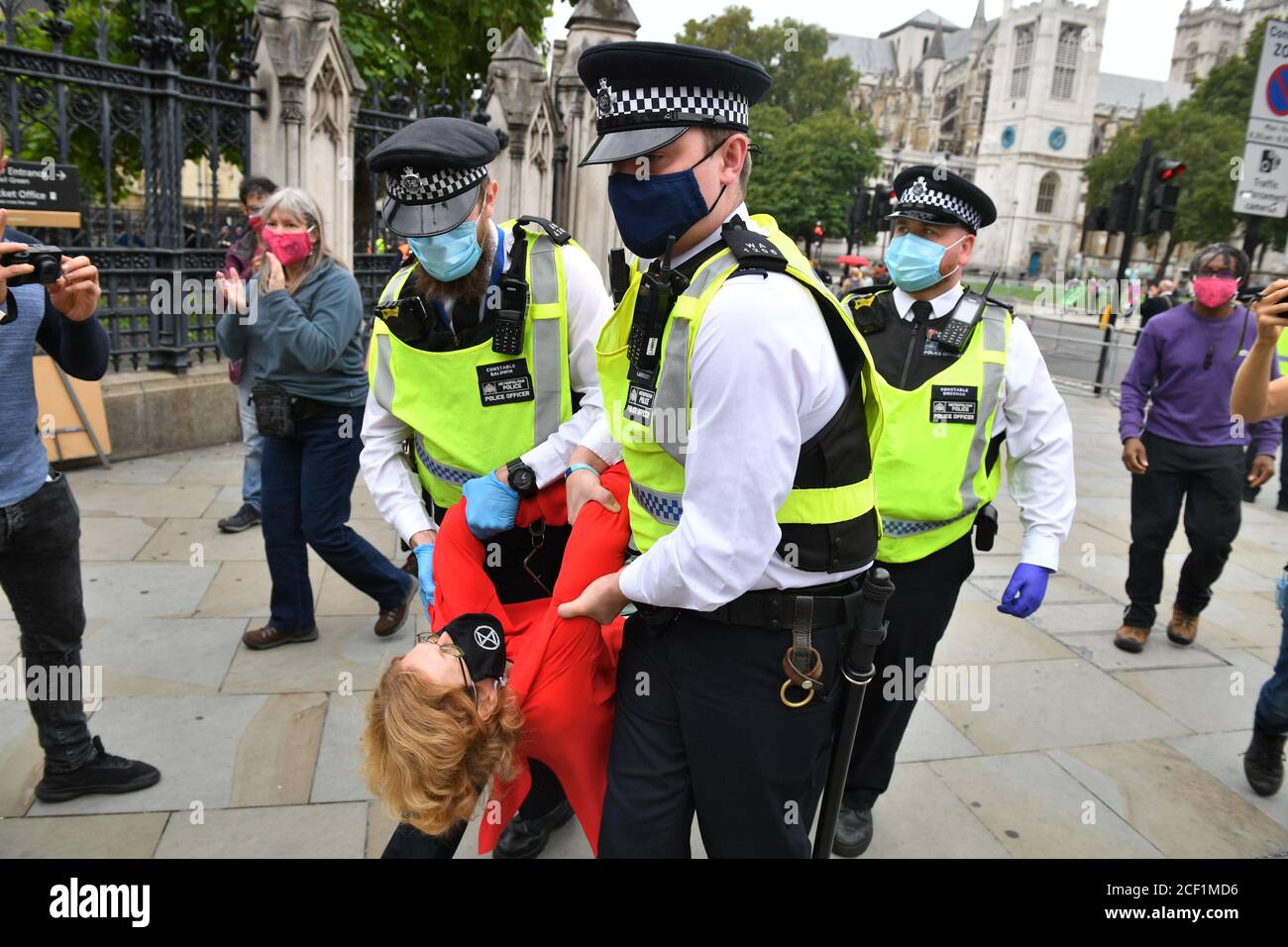 Police officers remove a protester from an Extinction Rebellion sit ...
