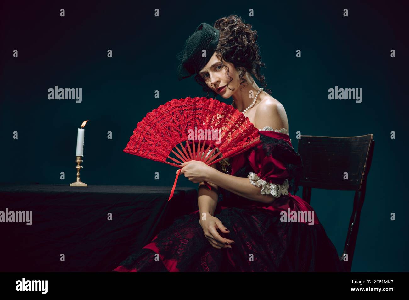 Secrets. Young woman as Anna Karenina isolated on dark blue background ...