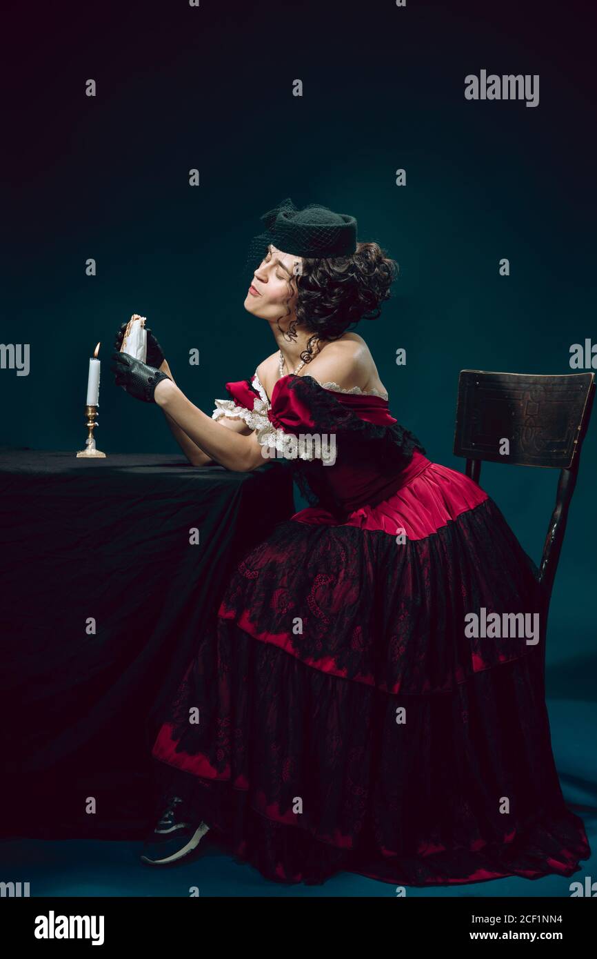 Happiness. Young woman as Anna Karenina isolated on dark blue ...