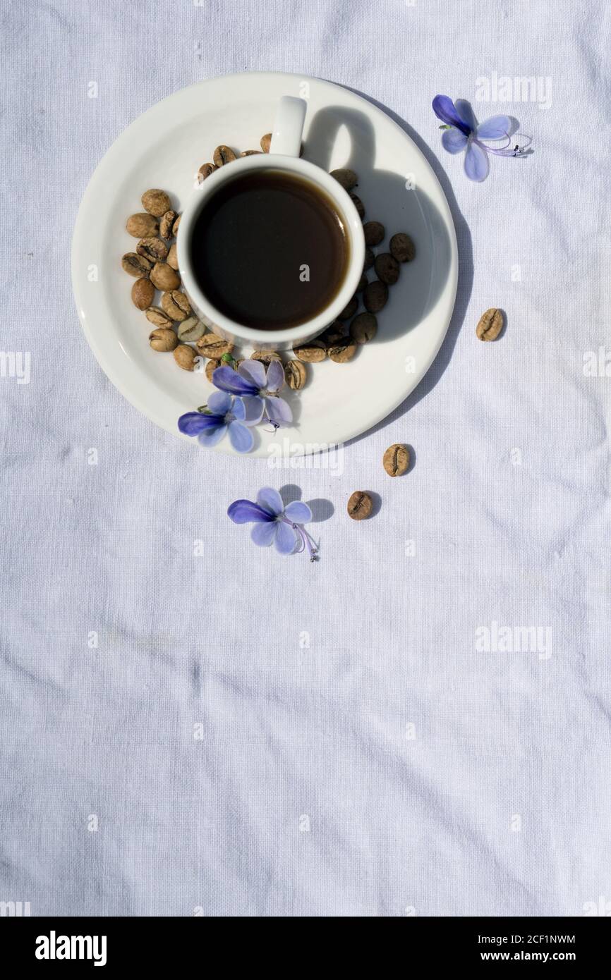 Flat lay Coffee composition with white cup and beans of coffe on linen ...