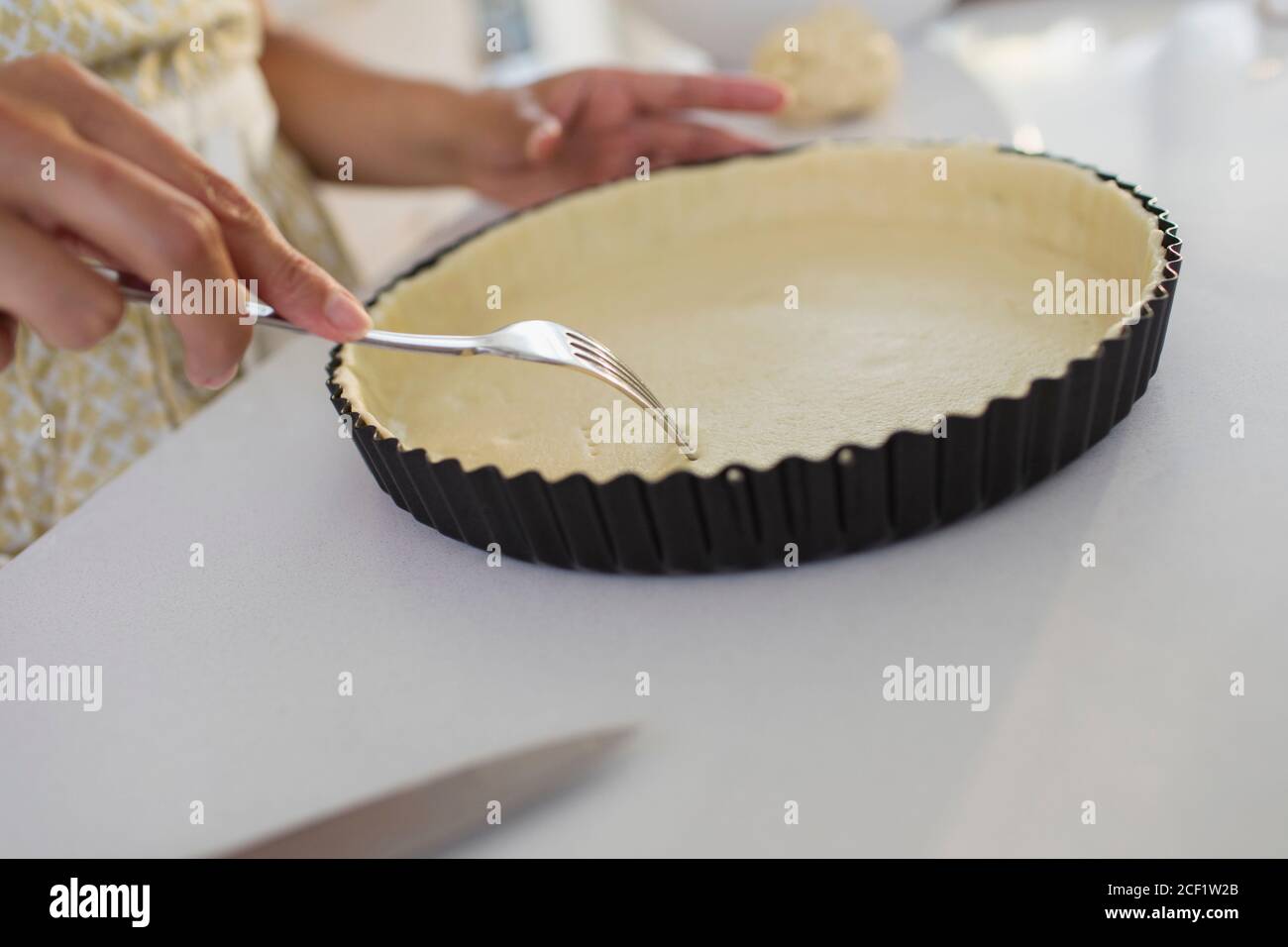 Close up woman baking poking holes into pie crust with fork Stock Photo ...