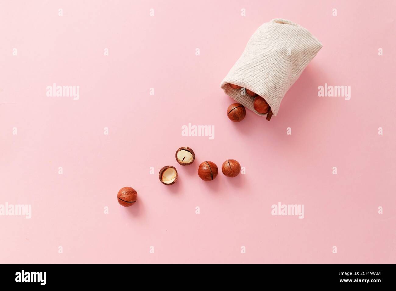 Macadamia nuts in a bag on a pink background design for poster, article ...