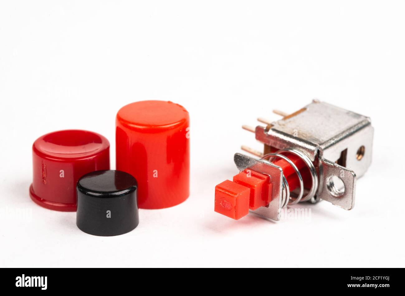 Miniature electric switches with red caps on isolated white background ...