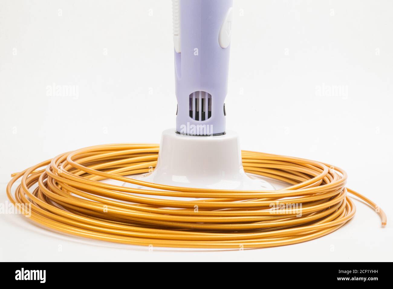 Closeup view of golden rolled cables around childrens 3D printing pen ...