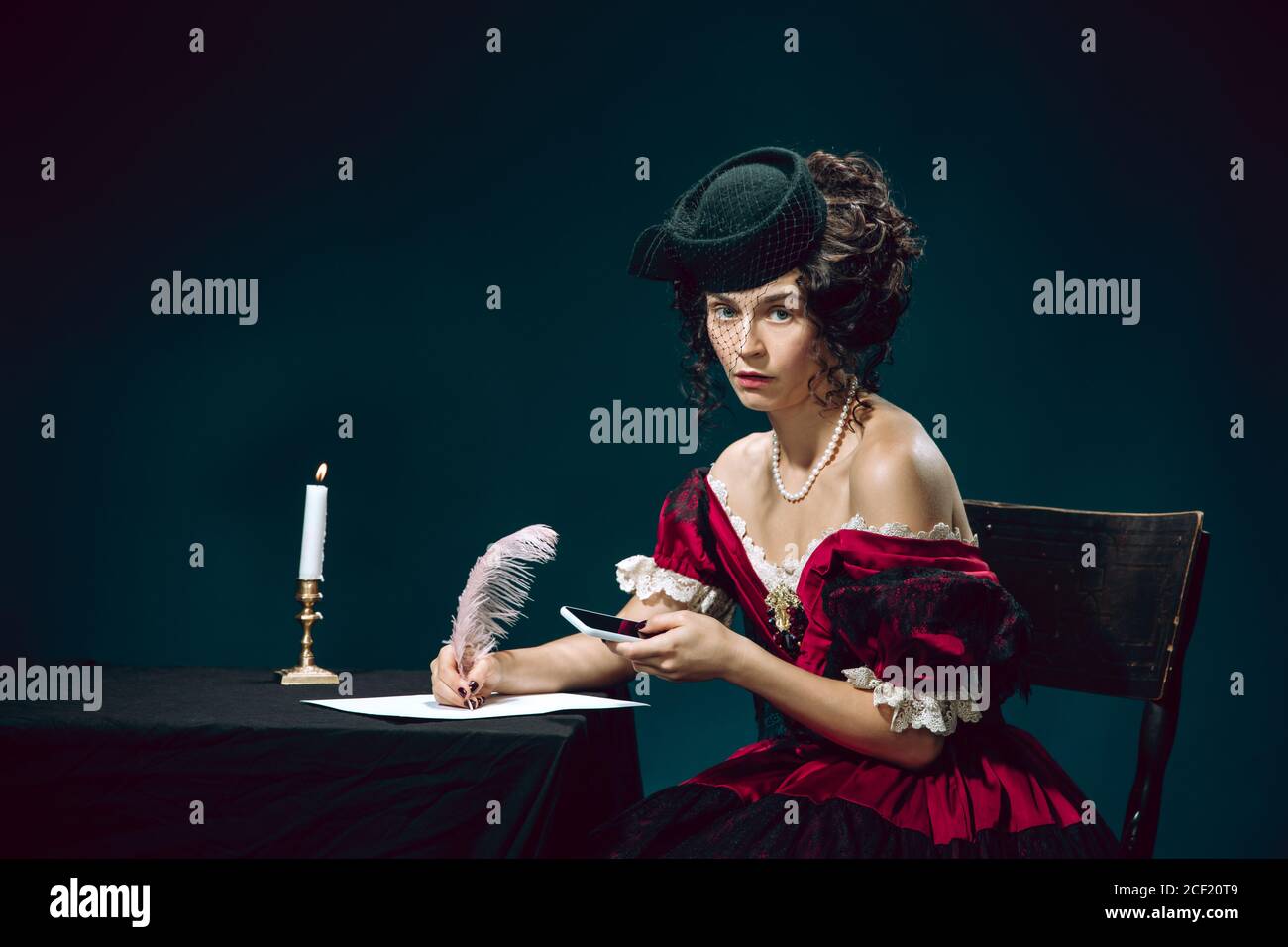 Texting. Young woman as Anna Karenina isolated on dark blue background ...