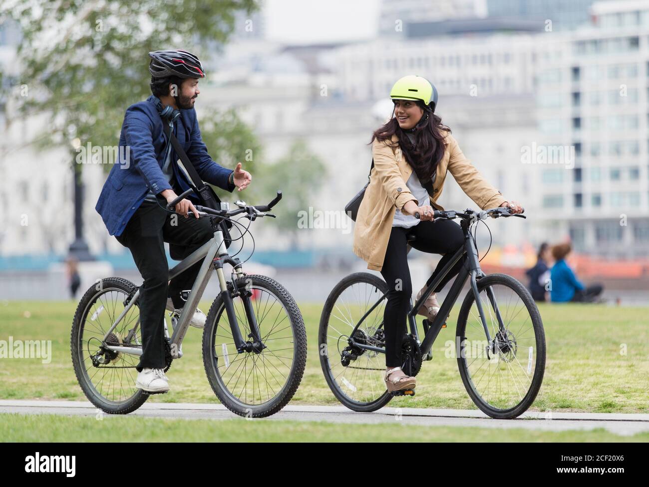 Business people riding bicycles and talking in city park Stock Photo ...