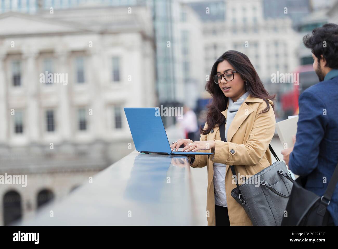 Business people using laptop on city bridge Stock Photo - Alamy