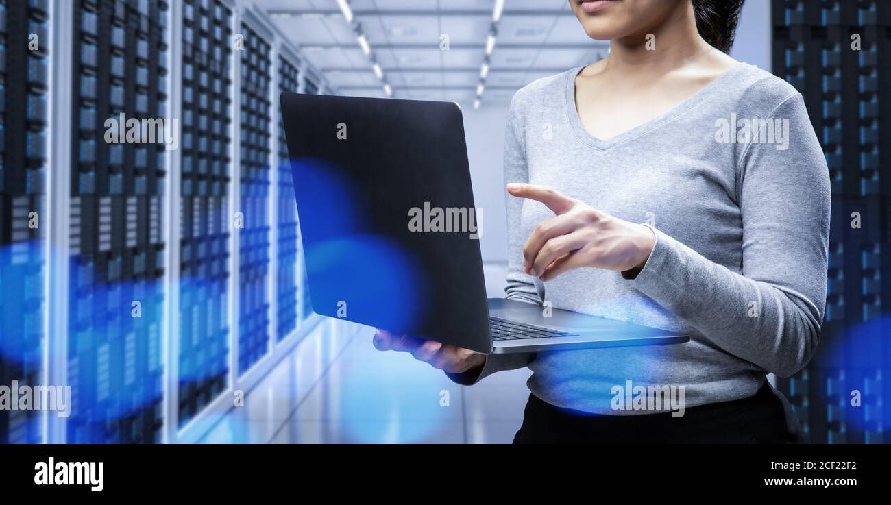 Female programmer with computer notebook in server room Stock Photo - Alamy