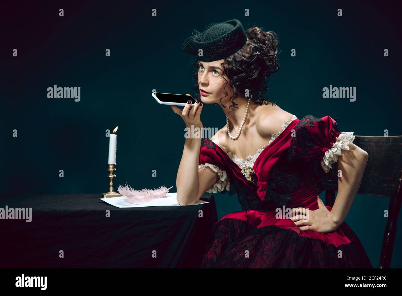 Recording message. Young woman as Anna Karenina isolated on dark blue ...