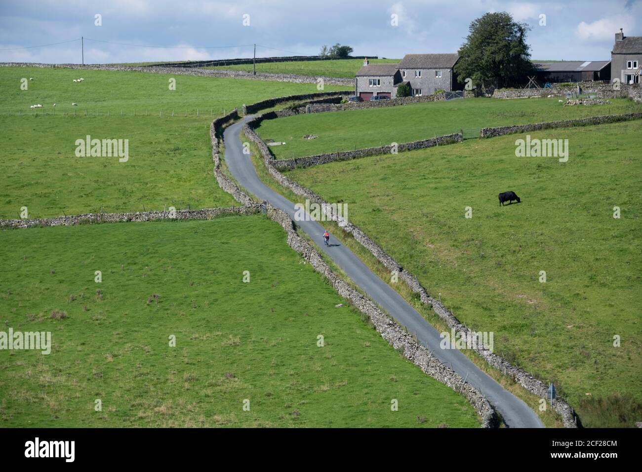 Female cyclist climbing a steep hill on her electric bike in the ...