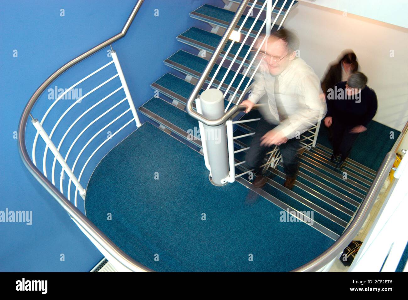 Staff using stairs in office UK Stock Photo - Alamy