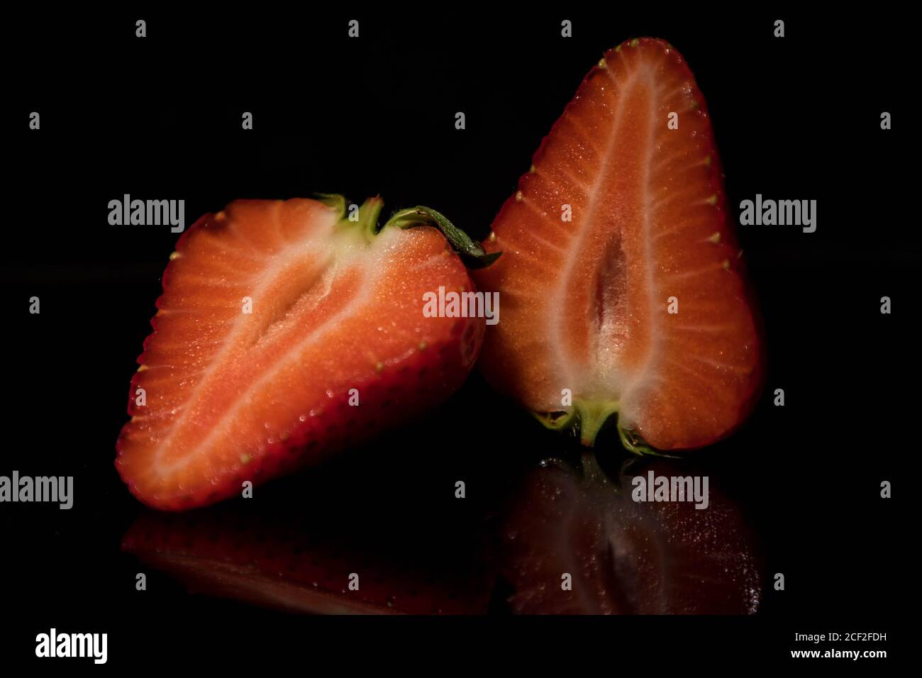 Strawberry cut in half black background Stock Photo - Alamy