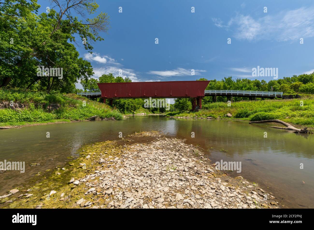 An old red covered bridge over a river Stock Photo - Alamy