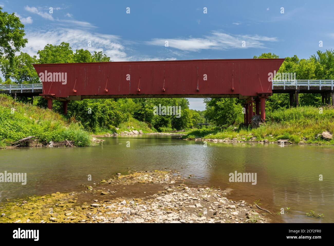 An old red covered bridge over a river Stock Photo - Alamy