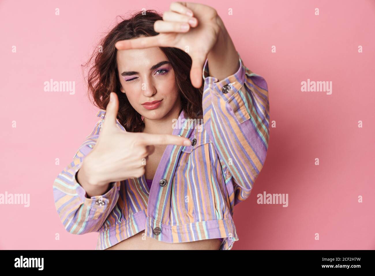 Image of redhead young woman winking and showing photo frame gesture ...