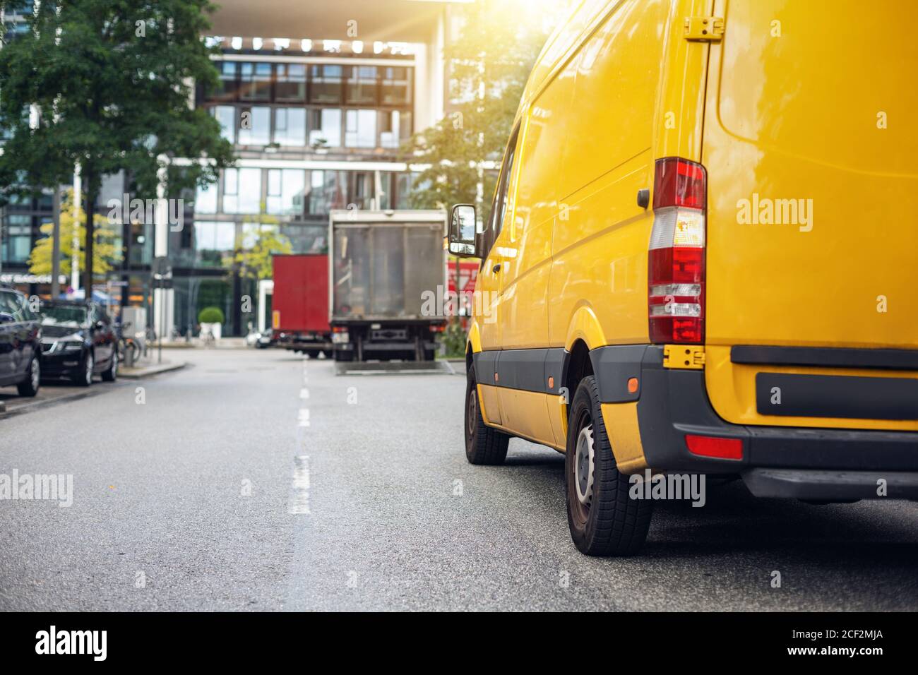 Yellow delivery van on a street inside a city Stock Photo - Alamy