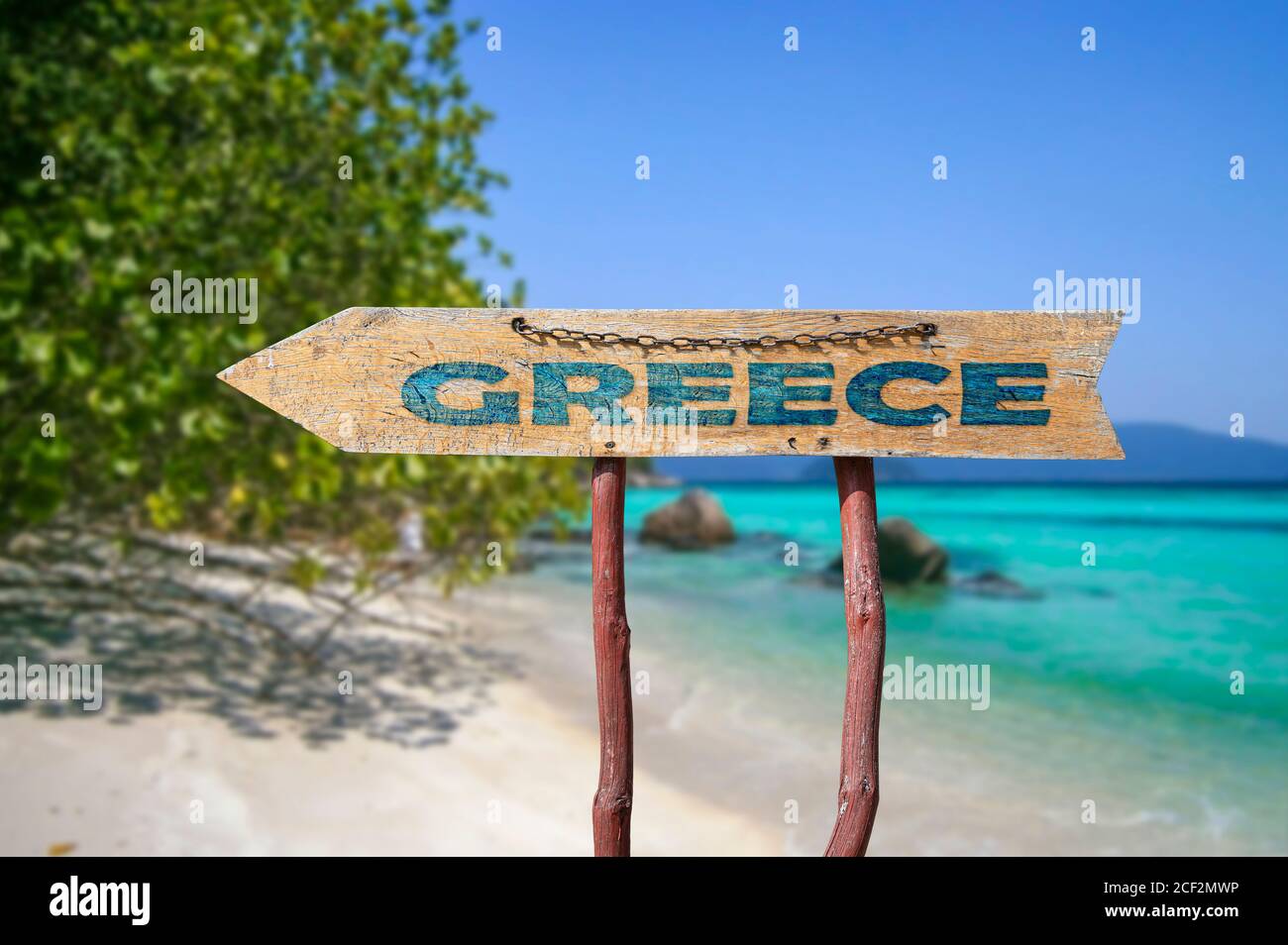 Wooden arrow road sign with word Greece against beach background ...