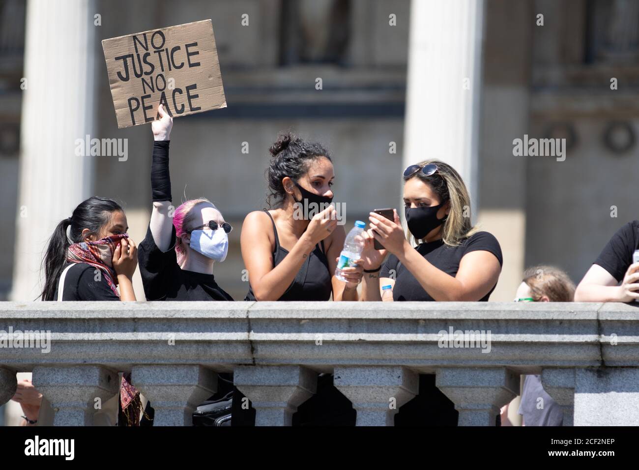 A woman holds a sign saying No Justice No Peace at a Black Lives ...
