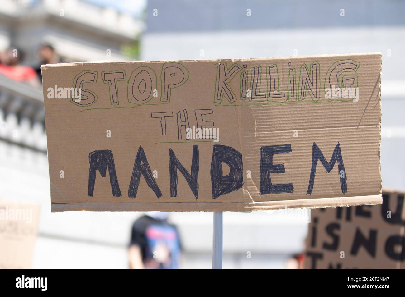 A homemade cardboard sign saying "Stop Killing The Mandem" at a Black ...
