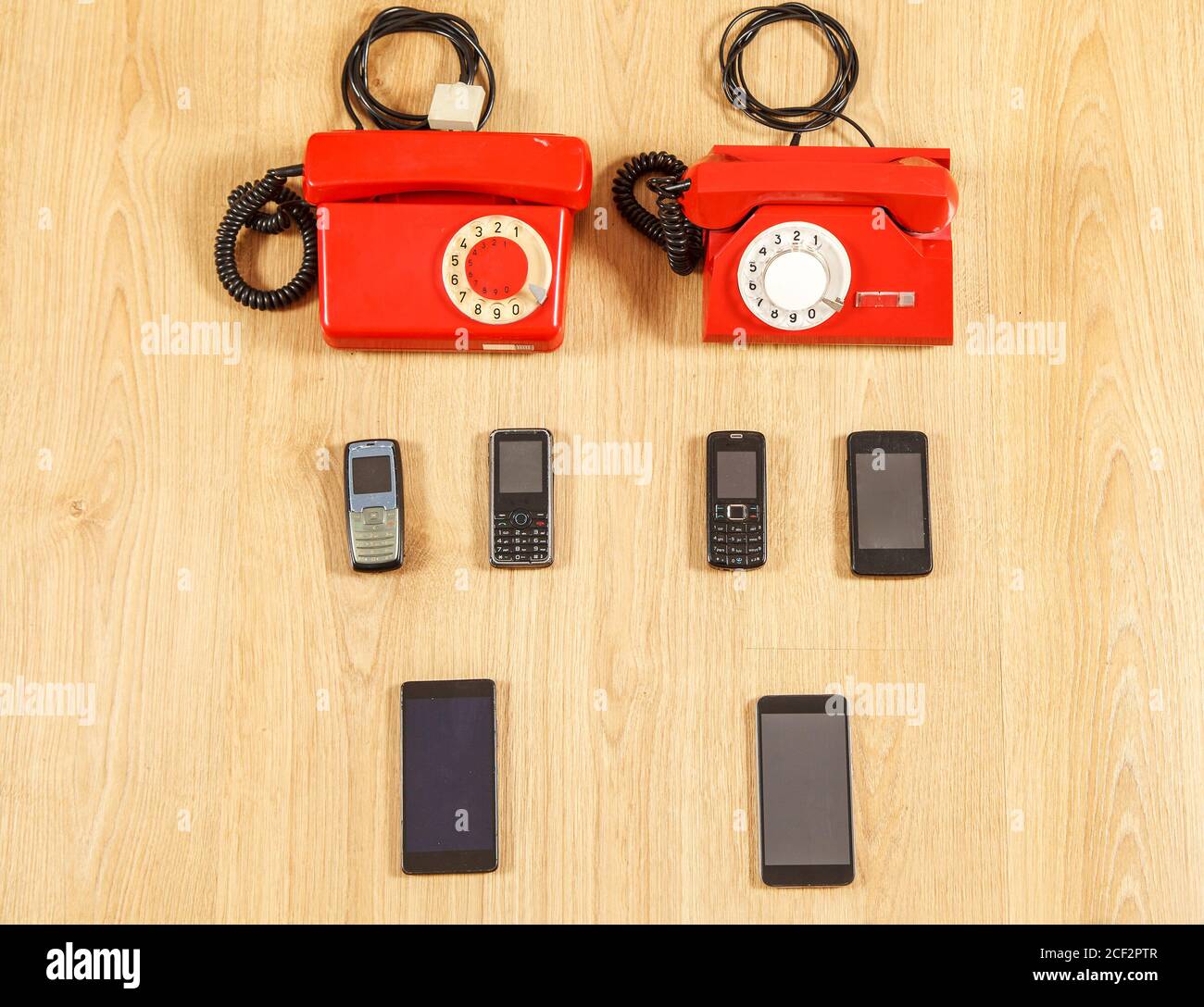set of various old phones and modern smartphones on yellow wooden ...