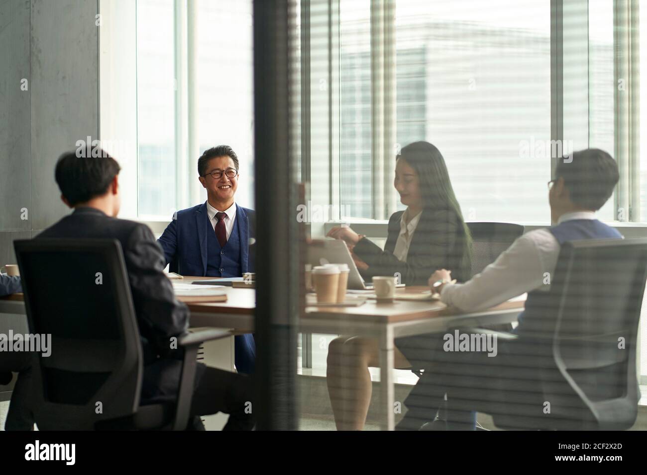 group of asian corporate executives meeting in conference room in ...