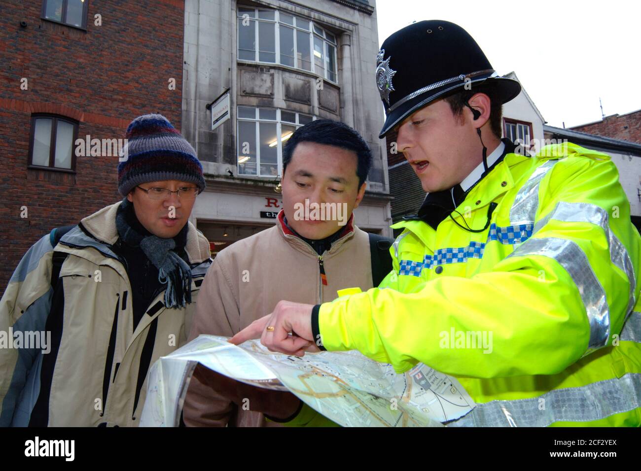 Policeman helping lost Japanese tourists find their way York UK Stock ...