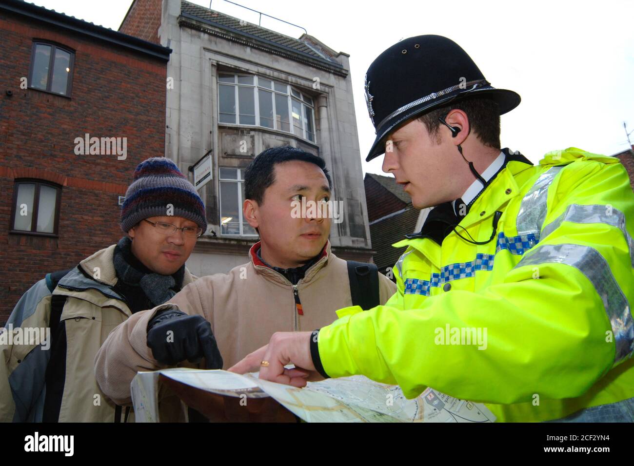 Policeman helping lost Japanese tourists find their way York UK Stock ...