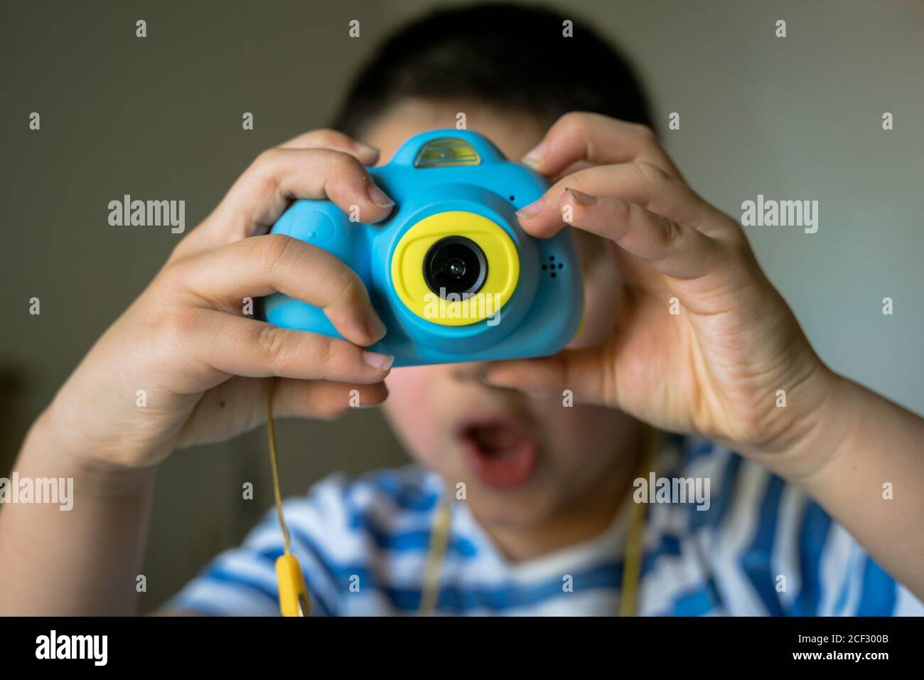 Little boy looking into a small toy camera with a shocked face Stock ...