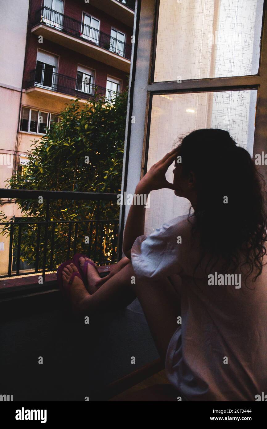 Monthly girl looking out the window leaning on the balcony Stock Photo ...